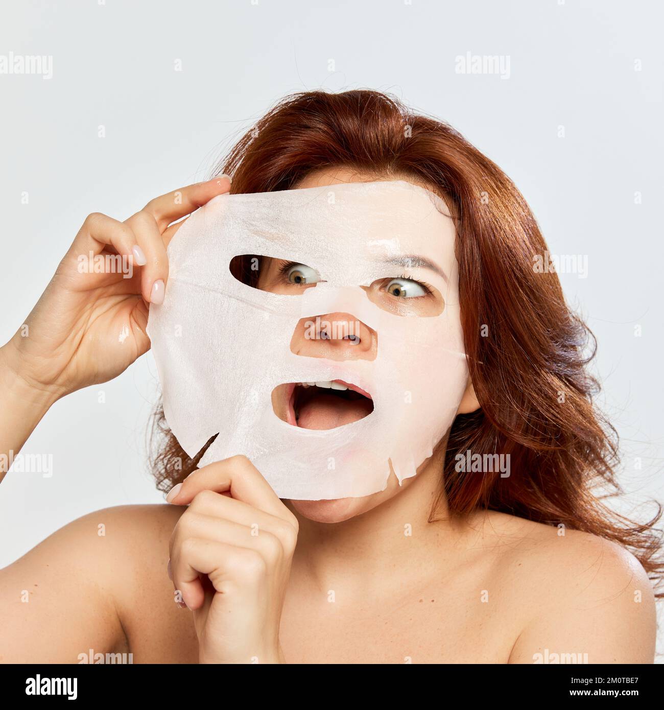 Emotive Red Haired Woman Taking Care After Skin Taking Off Moisturizing And Revitalizing Mask