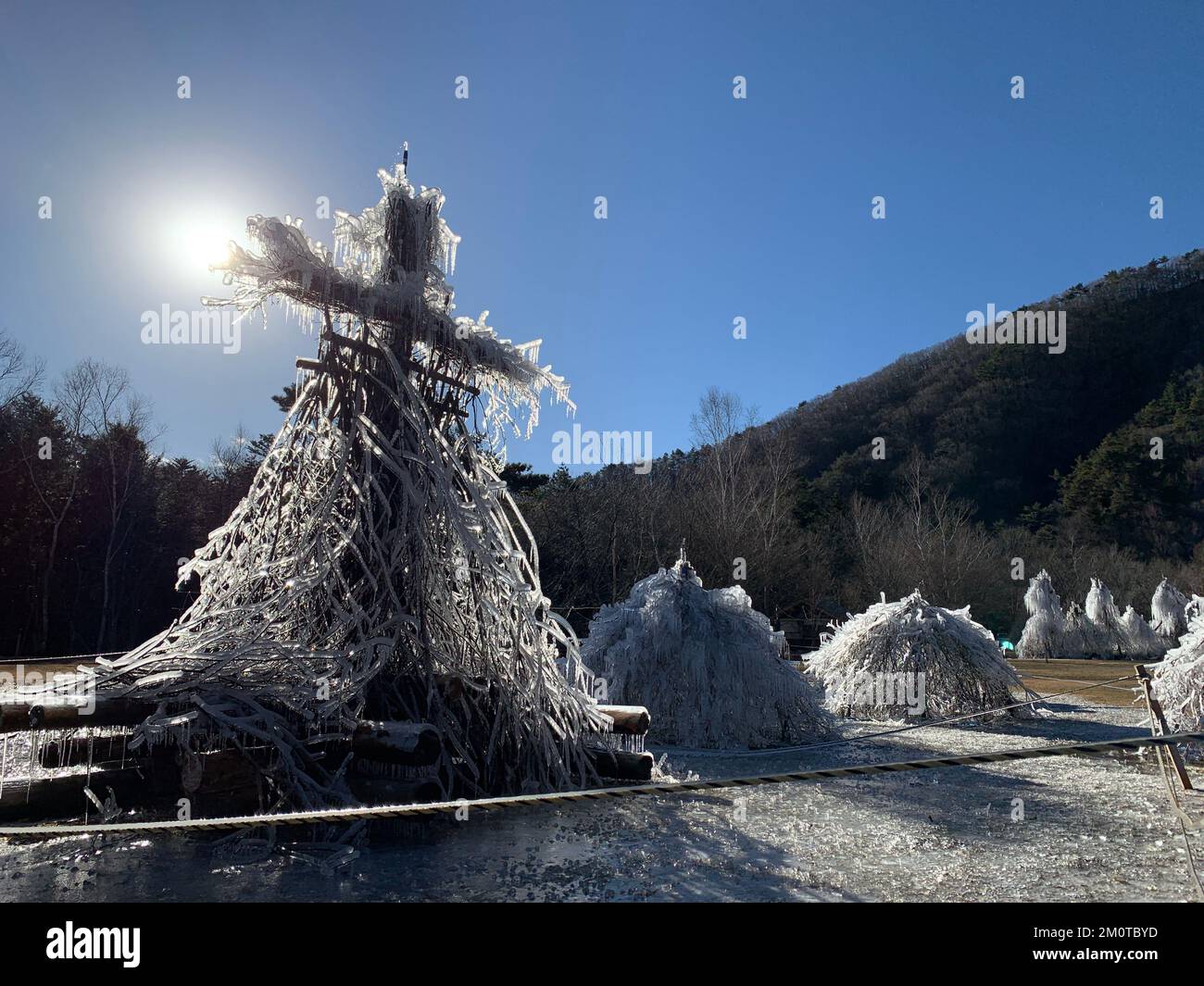 Ice covered huge cross with sun in the background Stock Photo - Alamy