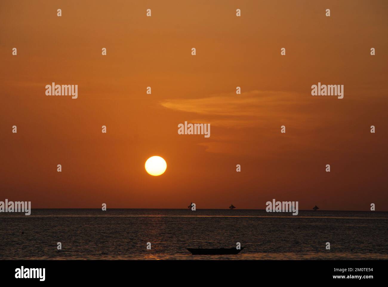 A beautiful sunset on the seashore with a cloudy sky in the background ...