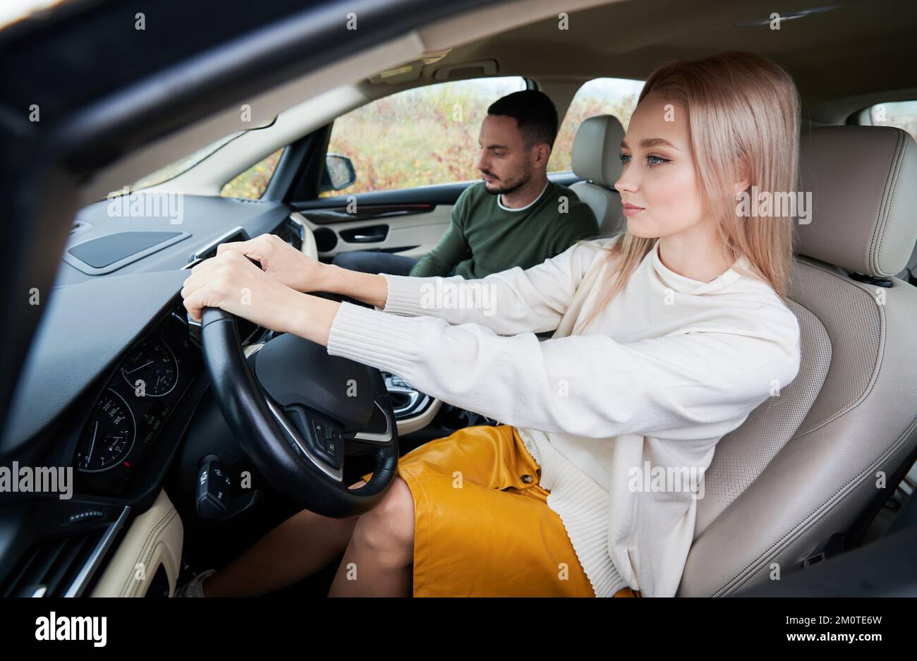 Happy man and woman traveling in car. Young couple sitting on front ...