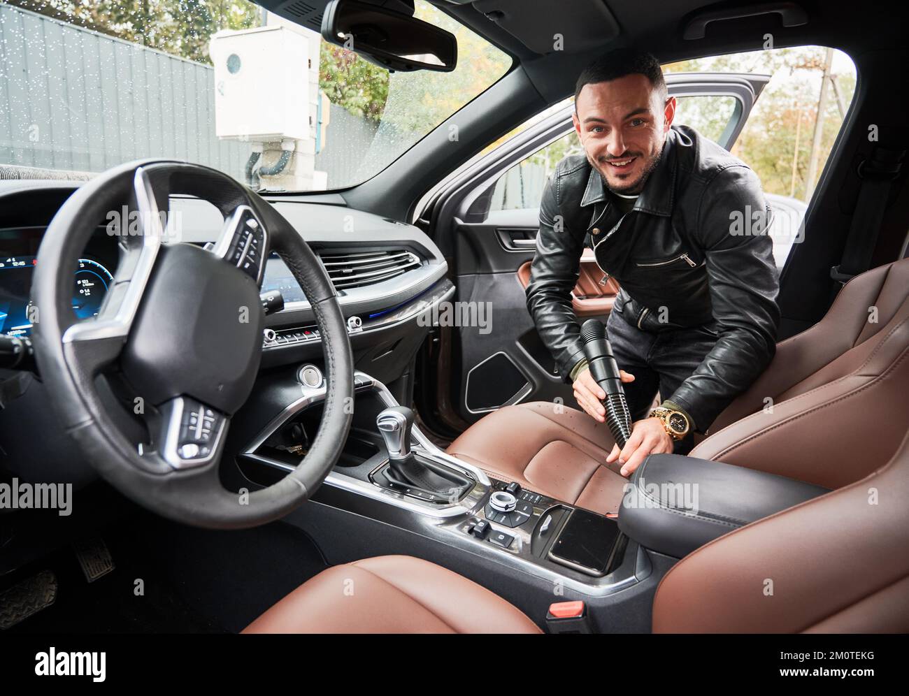 View from inside a car on young man washing car on carwash station ...