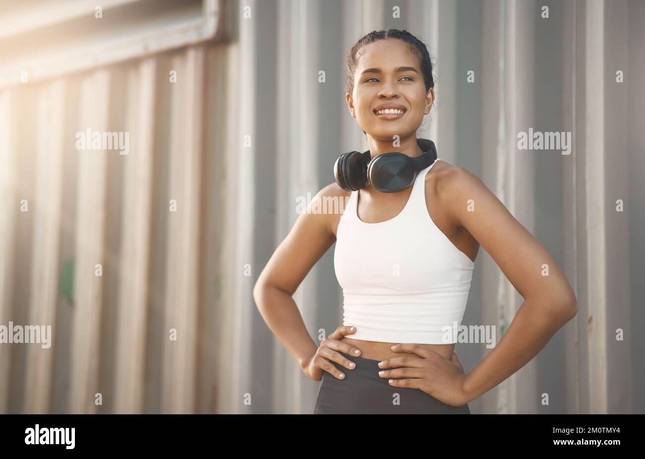 One fit young hispanic woman wearing headphones and standing ready with ...
