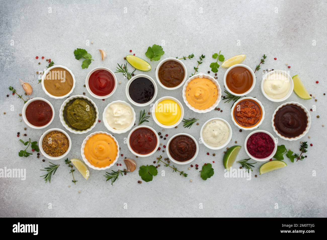 Different types of sauces in bowls with seasonings, rosemary and pepper ...