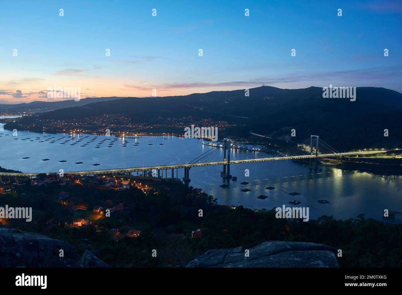 The bridge going over the river in the city during sunset Stock Photo ...