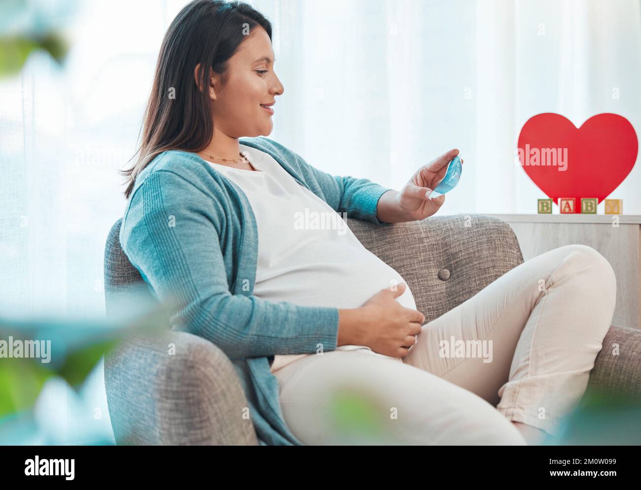 Pregnant woman, ultrasound and mother on sofa in home looking at ...