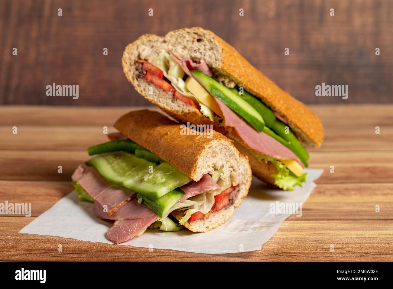 Baguette sandwich. Sandwich with salami, smoked meat, olives, lettuce ...