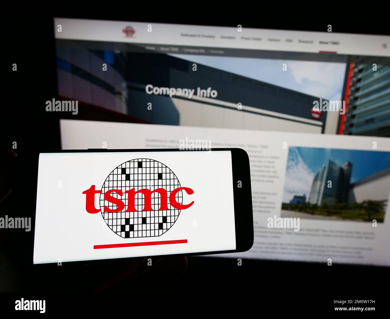 Person holding smartphone with logo of Taiwan Semiconductor ...