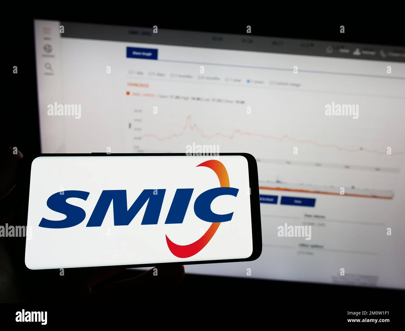 Person holding phone with logo of Semiconductor Manufacturing ...