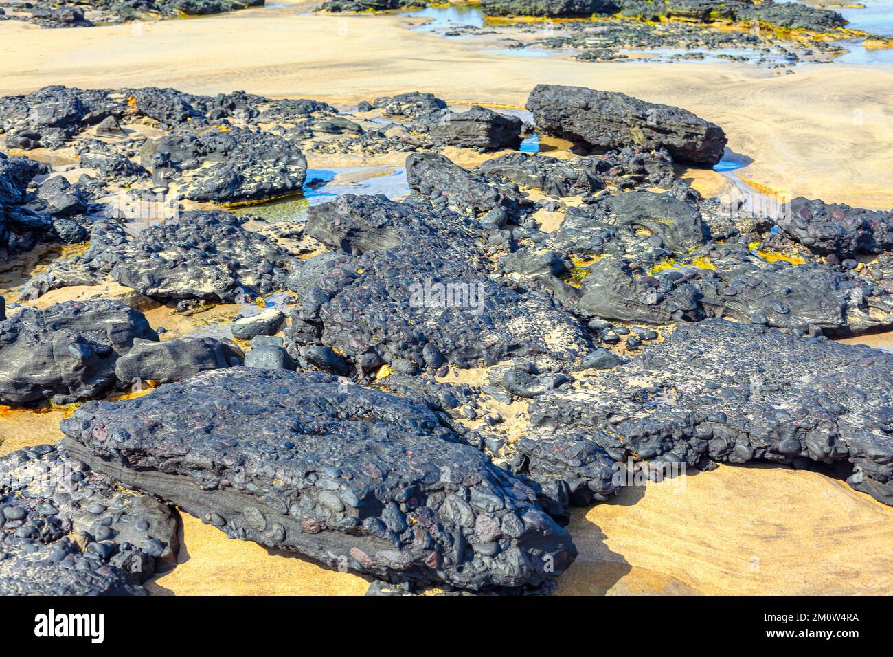 Volcanic Rocky Coast . Sandy beach with lava rock formations Stock ...