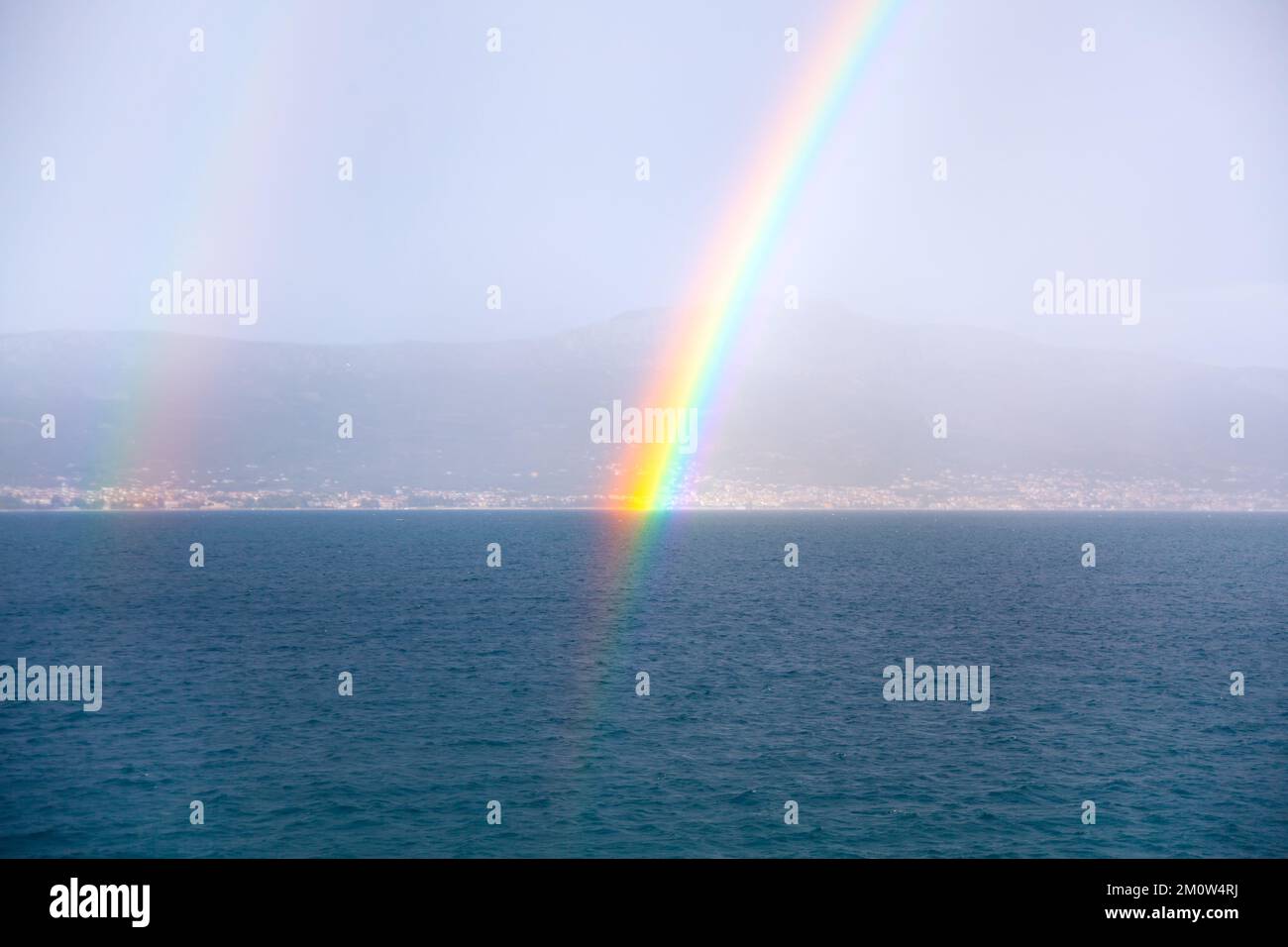 Real rainbow over the sea . Natural phenomenon with spectrum of colors ...
