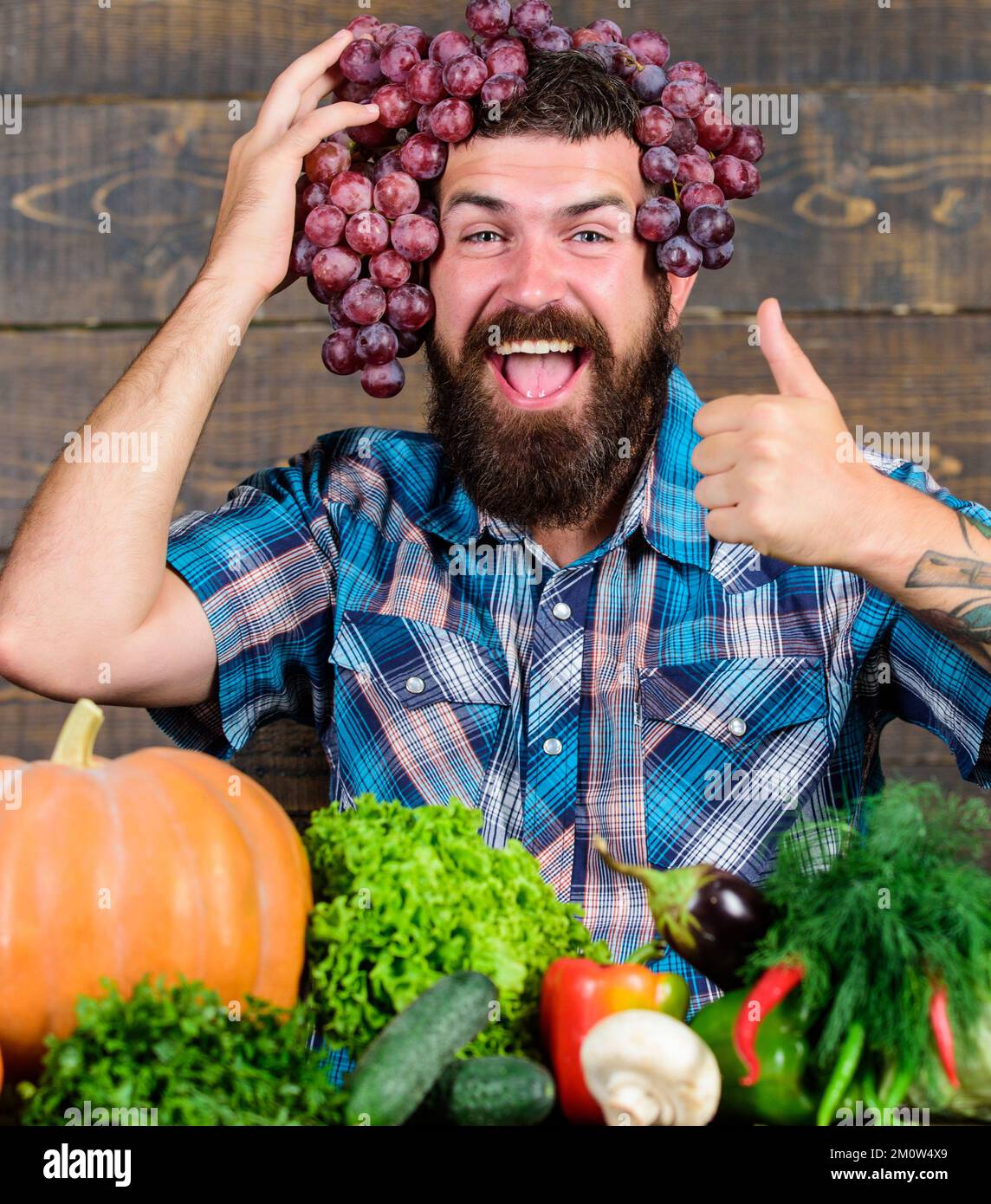 Farming concept. Farmer proud of grapes harvest. Man hold grapes wooden ...
