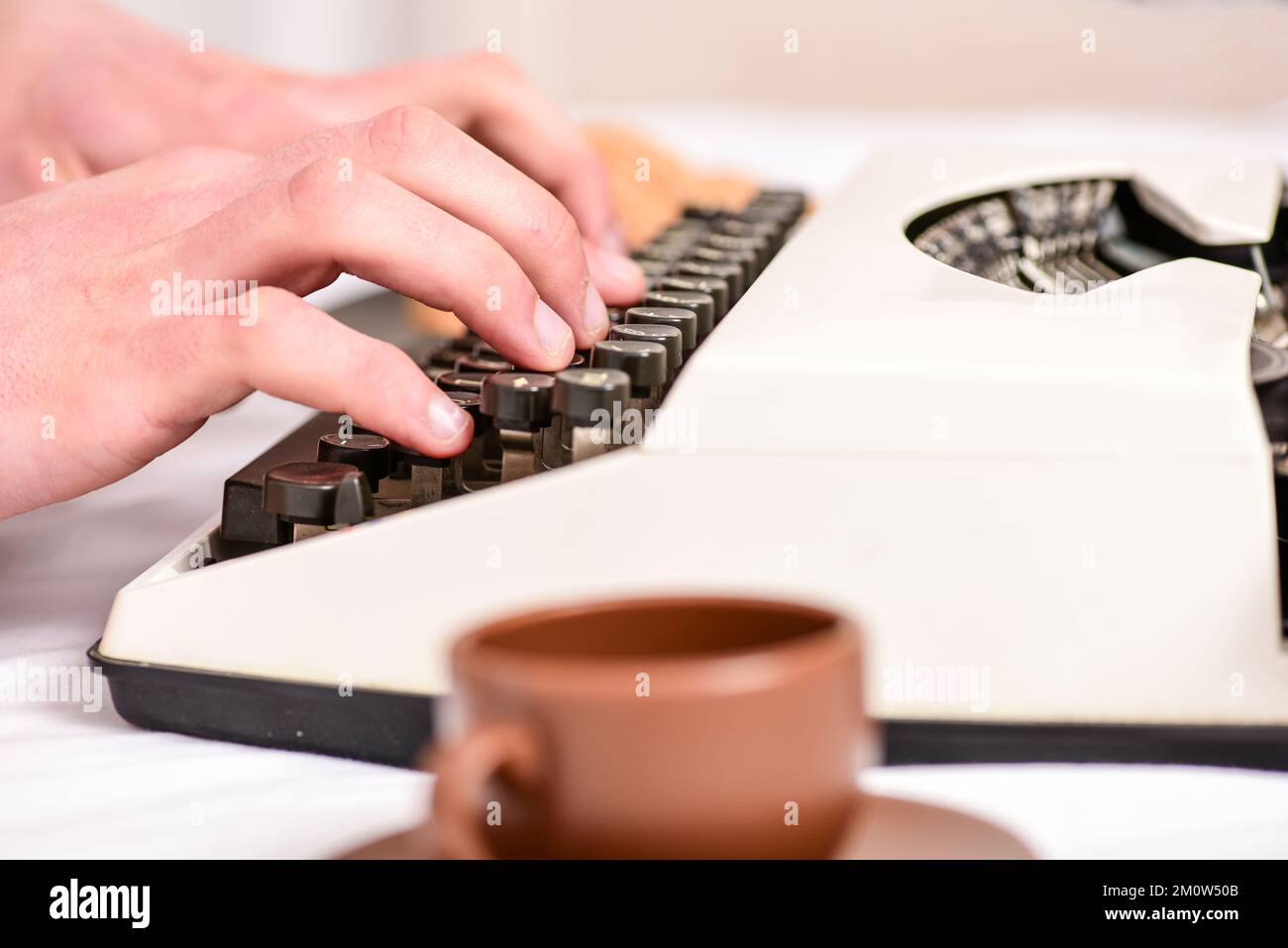 Male hands type story or report using white vintage typewriter ...