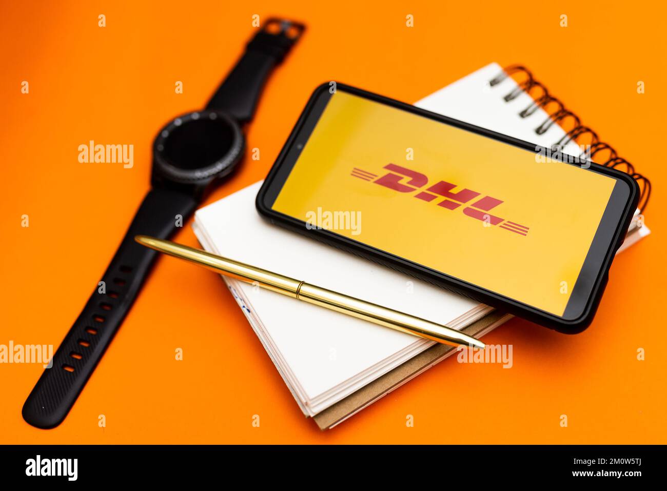 In this photo illustration a DHL logo seen displayed on a smartphone ...