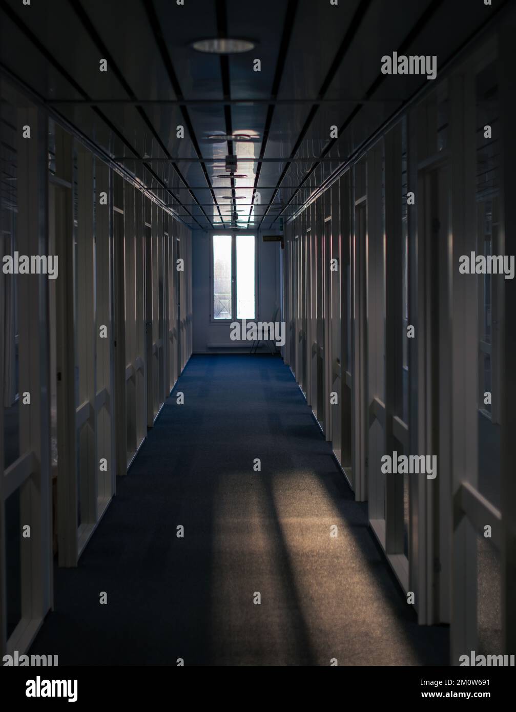 A vertical shot of a narrow hallway with a long rectangle window Stock ...