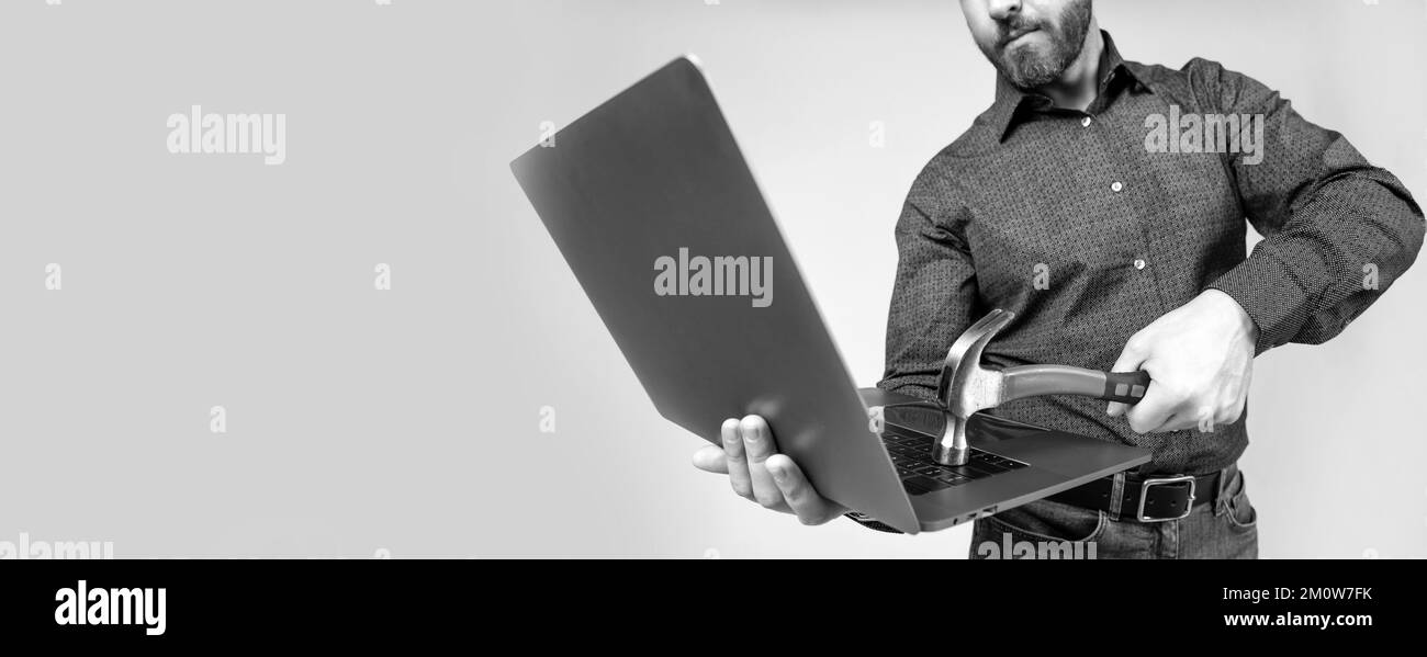 Bearded man cropped view beat with hammer breaking into computer grey ...