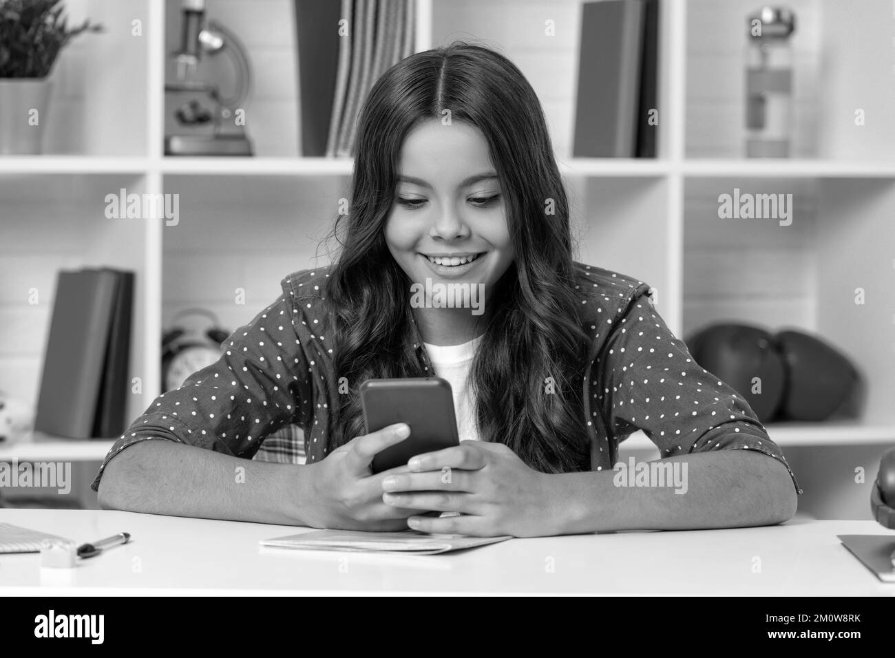 happy kid long curly hair texting on smartphone in classroom, message ...