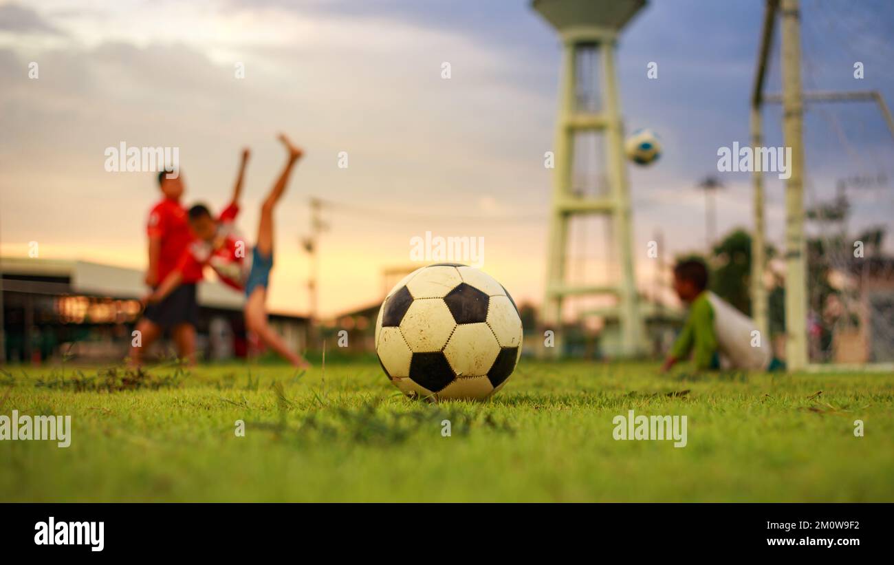 action sport outdoors of a group of kids having fun playing soccer ...