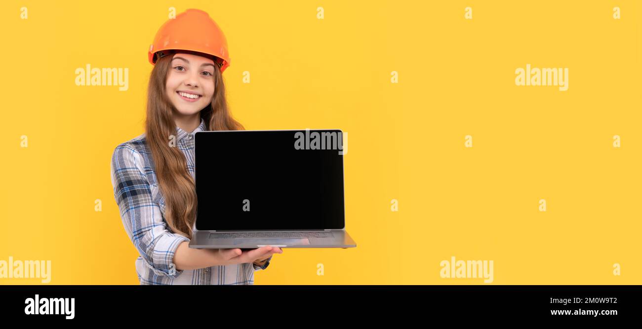 Builder teenager girl in helmet. teen girl in helmet presenting laptop ...