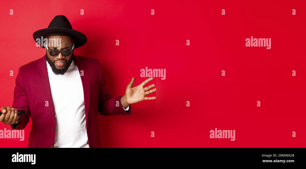 Passionate black male singer performing against red background, singing ...