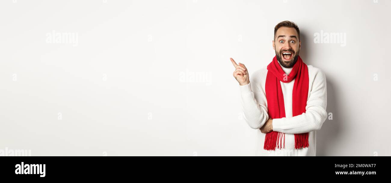 Christmas shopping and winter holidays concept. Surprised man pointing ...