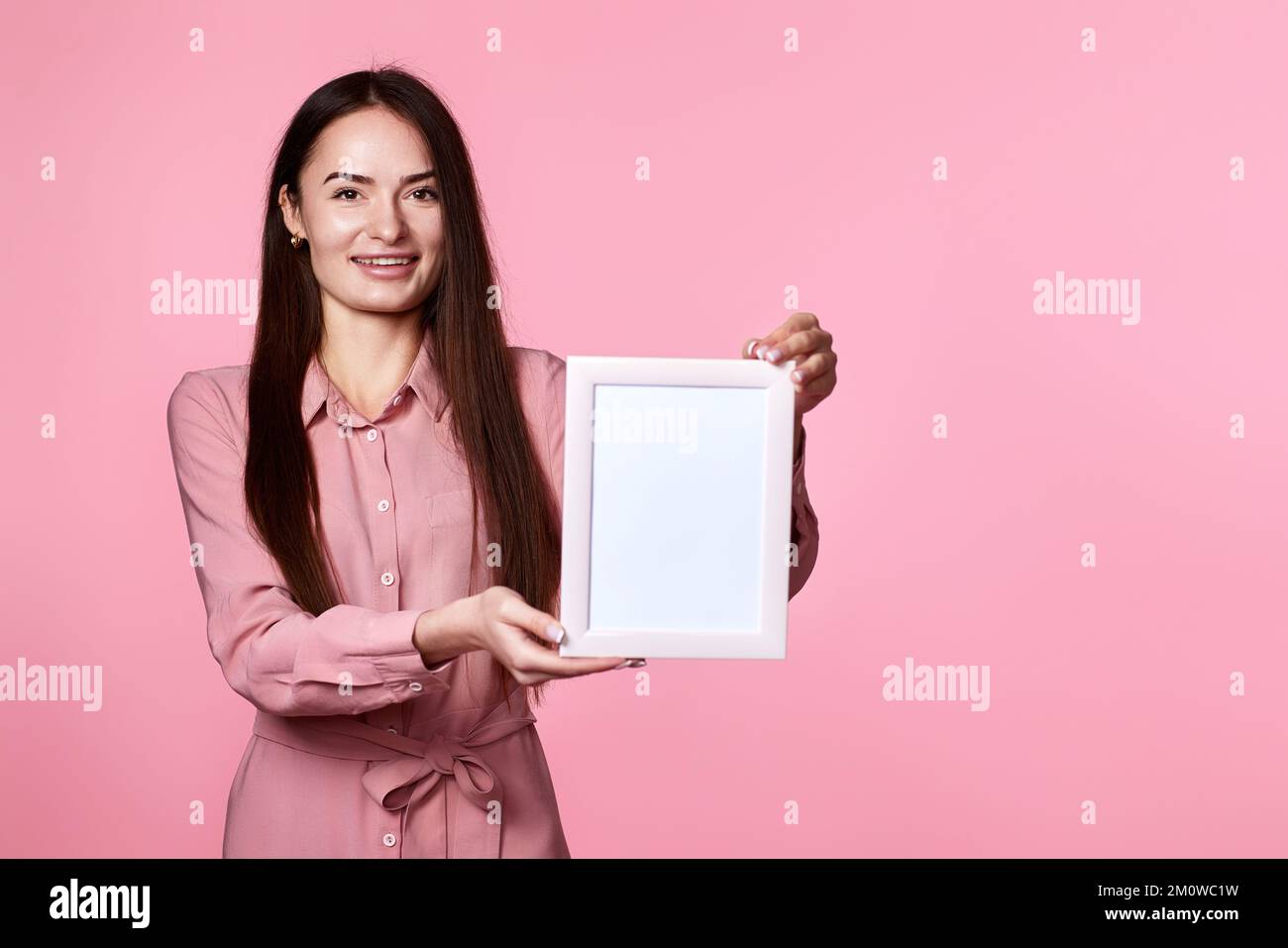 young woman in pink dress holding white frame Stock Photo - Alamy