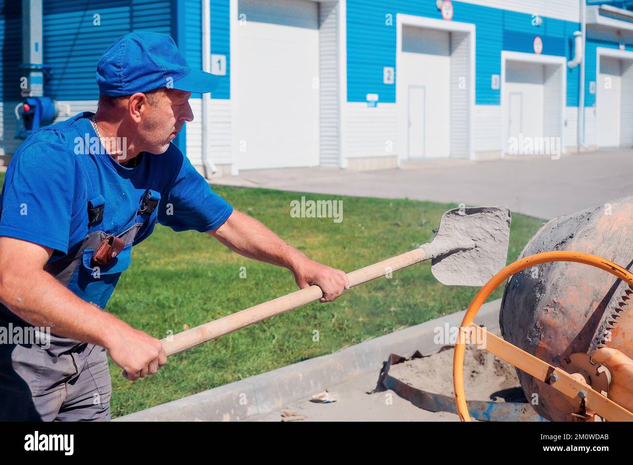 Uniformed construction worker works on construction site on summer day ...