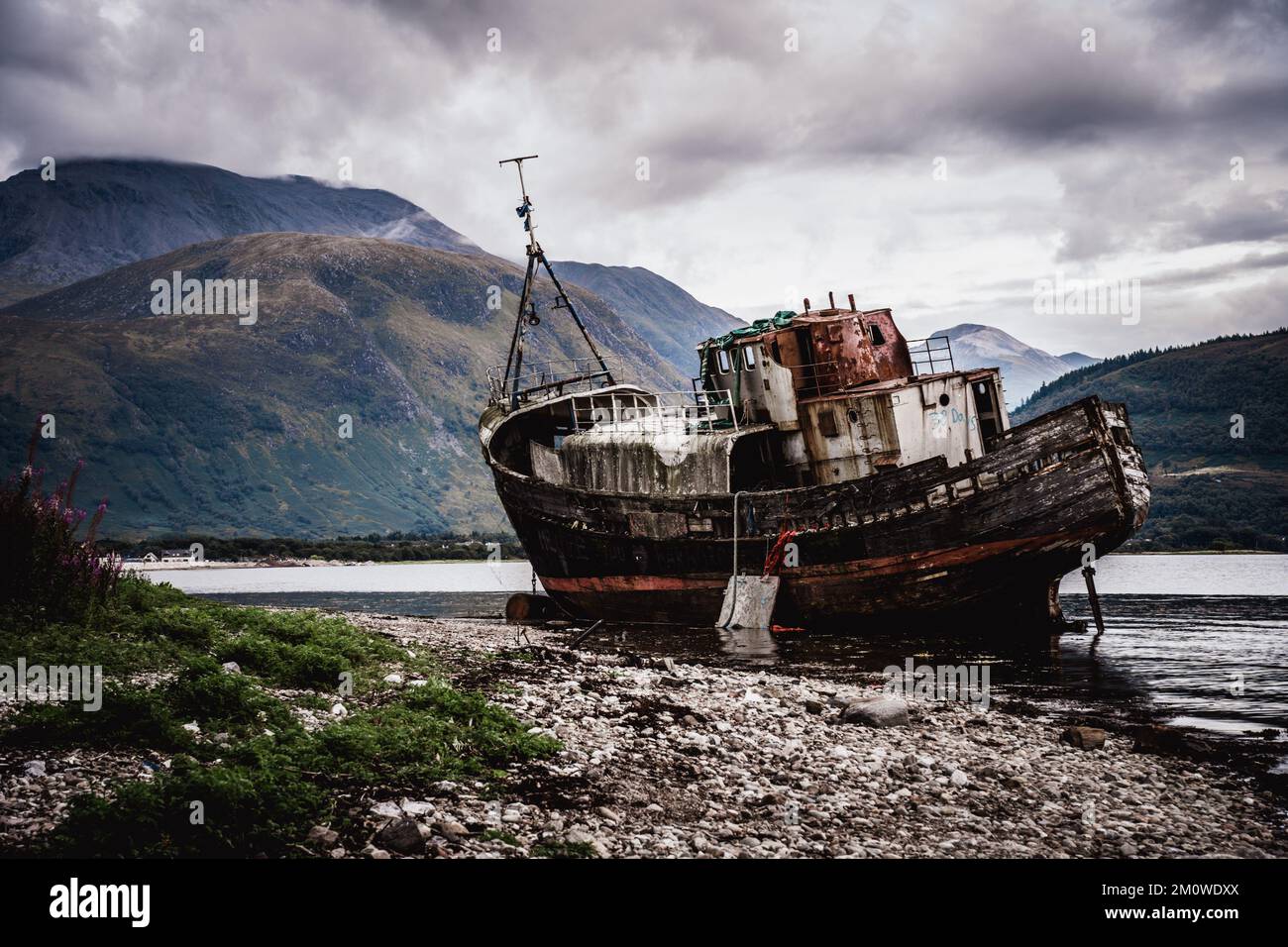 The abandoned Old Boat of Caol in Scotland with mountains under a ...