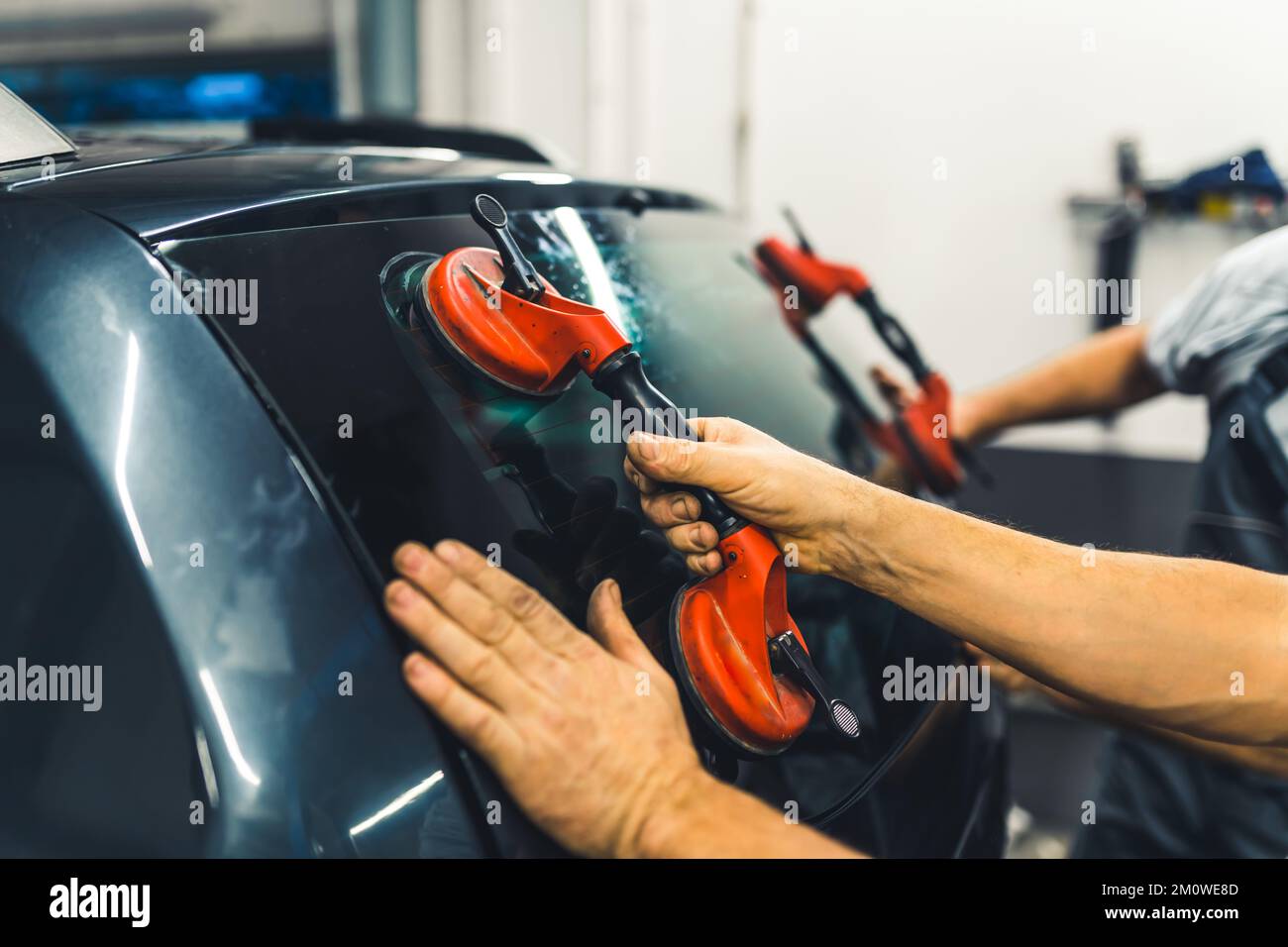 Closeup indoor portrait of car rear window being removed with the use ...