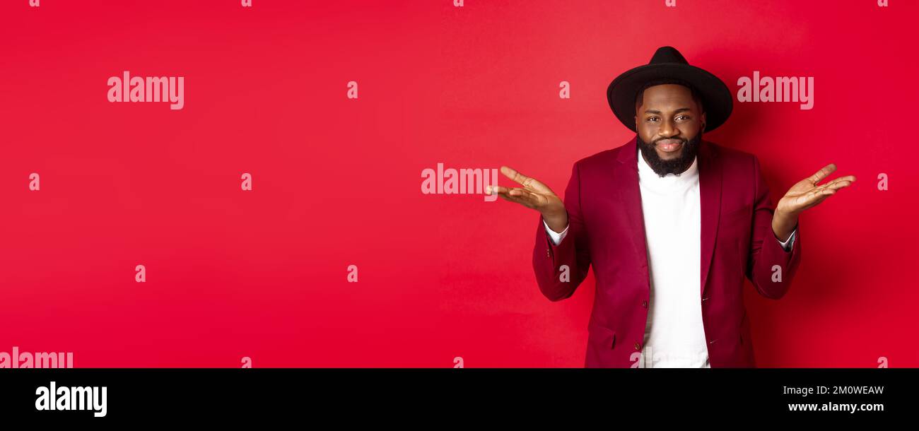 Clueless and unbothered Black man shrugging with indifferent look, dont ...