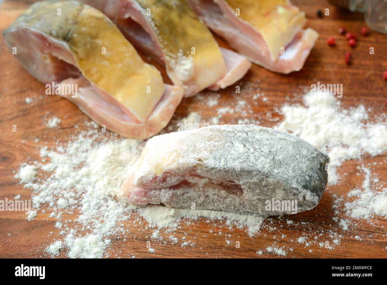 Fresh, raw carp fish slices breaded in flour. Preparing fish for frying ...
