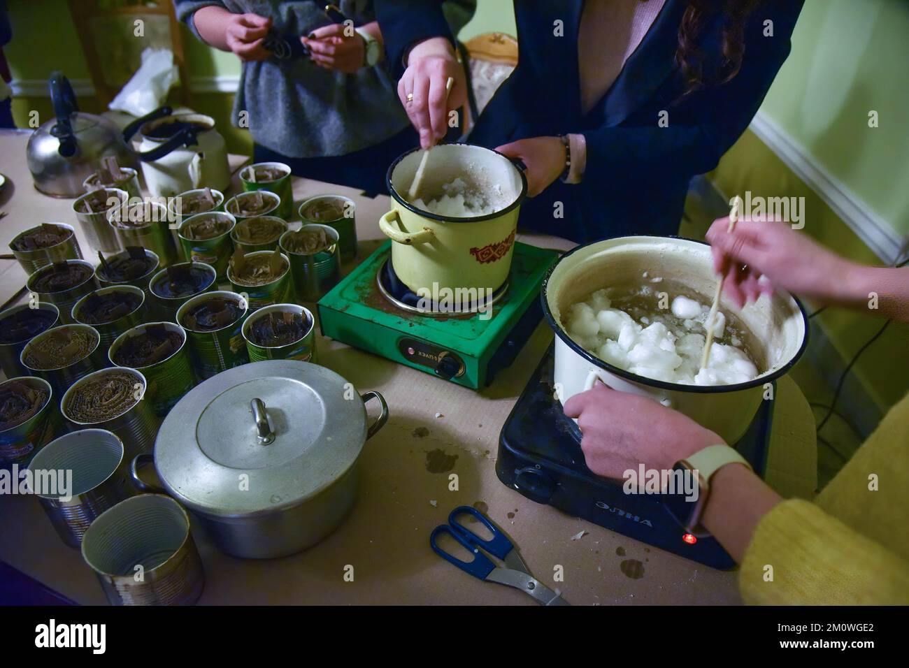 Volunteers melt paraffin to make trench candles, which will be given to ...