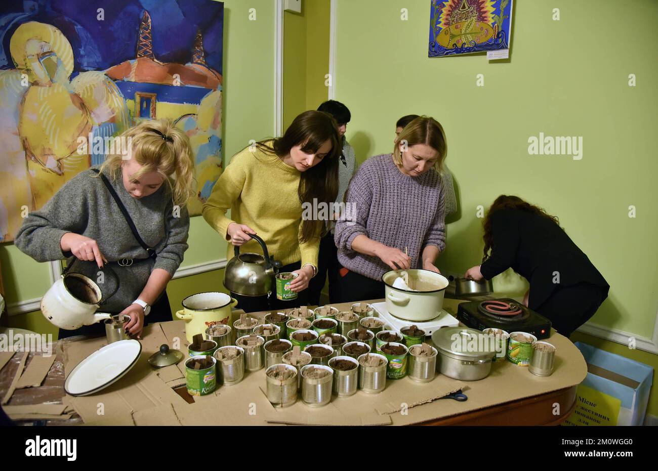 Volunteers melt paraffin and fill prepared jars with it to make trench ...