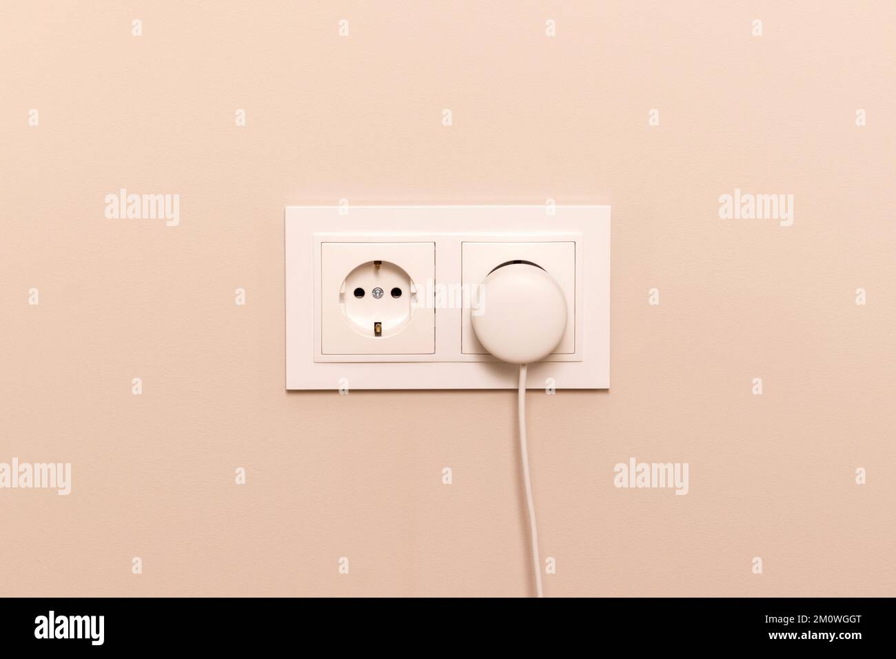 Group of white european electrical outlets with round plug inserted ...