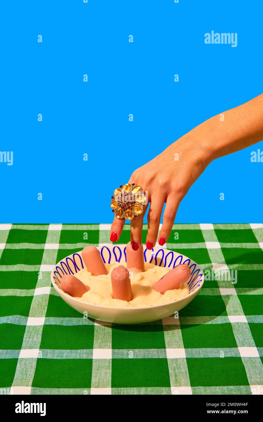 Female hand over plate with mashed potatoes and sausages on green ...