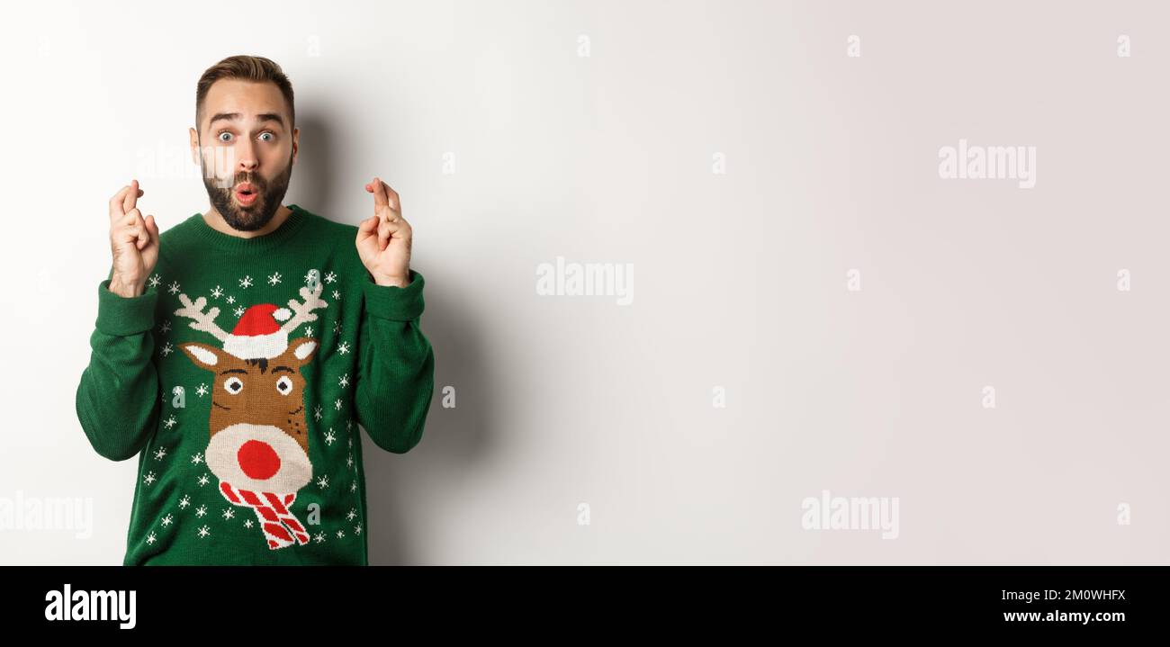 Christmas, holidays and celebration. Excited guy making wish, keep ...