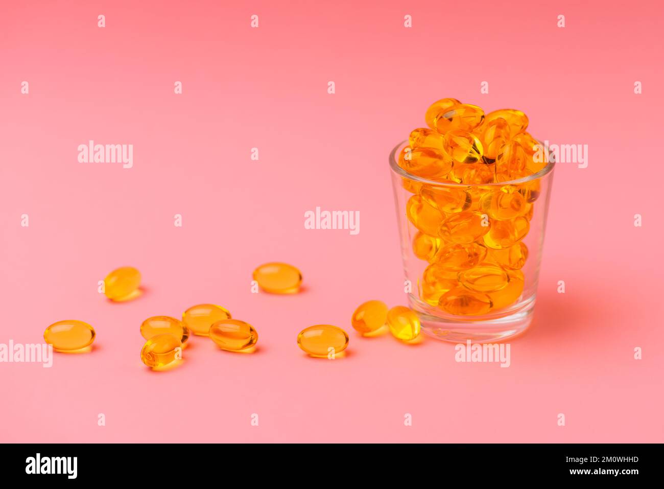 Close-up view of Omega 3 or fish oil capsules in a glass beaker on a ...