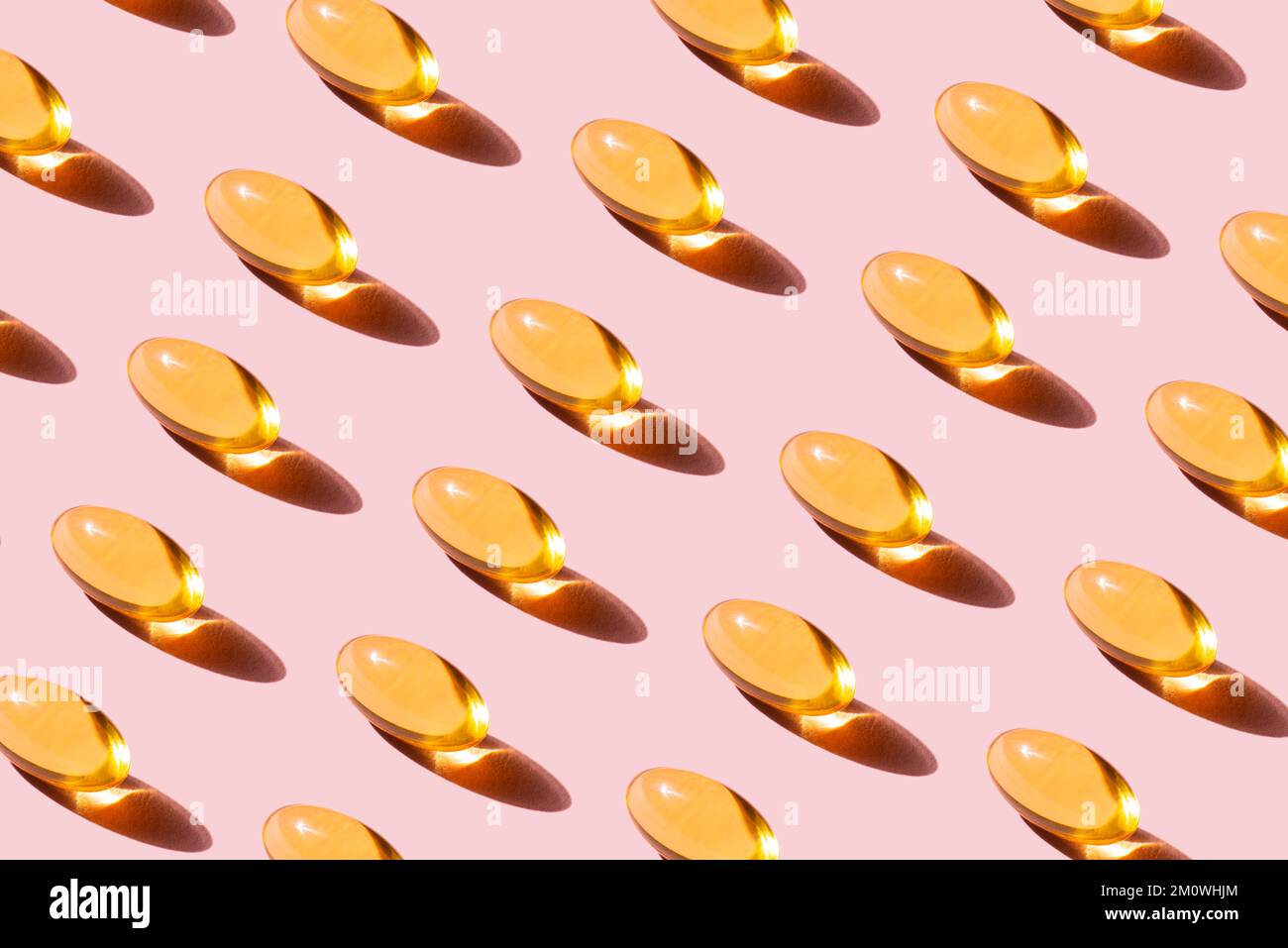 Pattern of yellow Fish Oil capsules with Omega-3 repetition on Pink ...