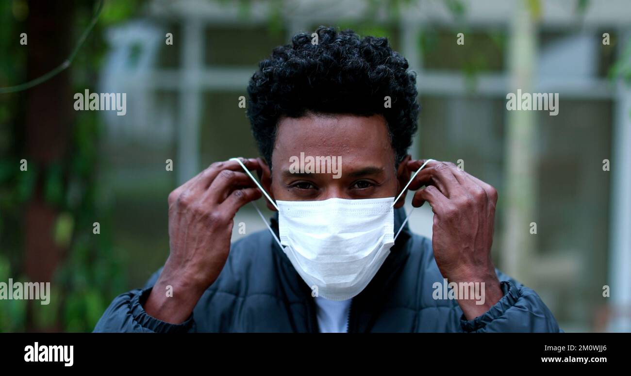 African american black man putting on virus anti-pollution mask and ...