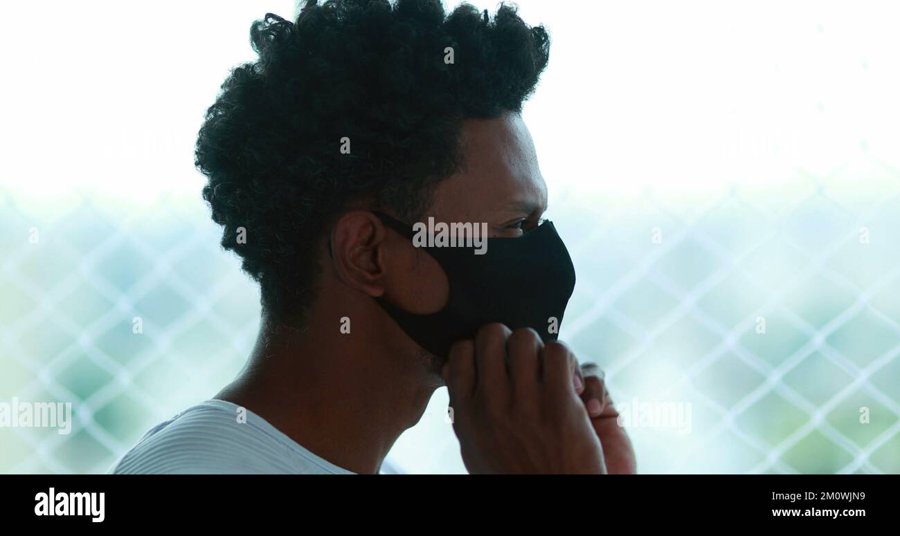 African american man putting on covid-19 virus mask. Black person ...