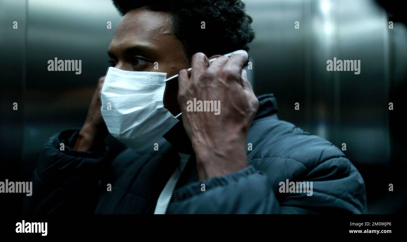 African american man wearing covid mask inside elevator, virus ...