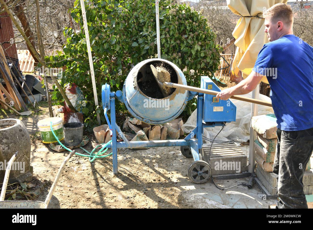 The mason loads the sand manually with a shovel into the concrete ...