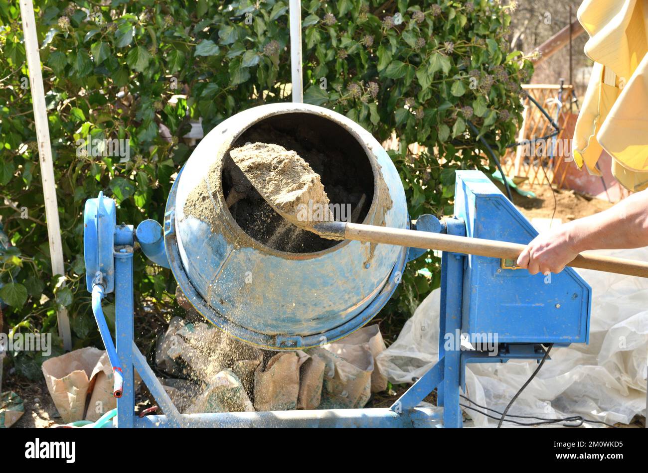 The mason loads the sand manually with a shovel into the concrete ...