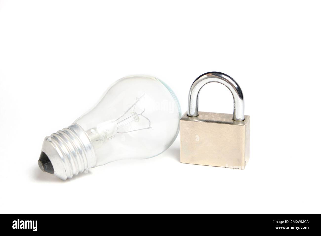 Incandescent lamp and lock on white background.Concept of power outage ...