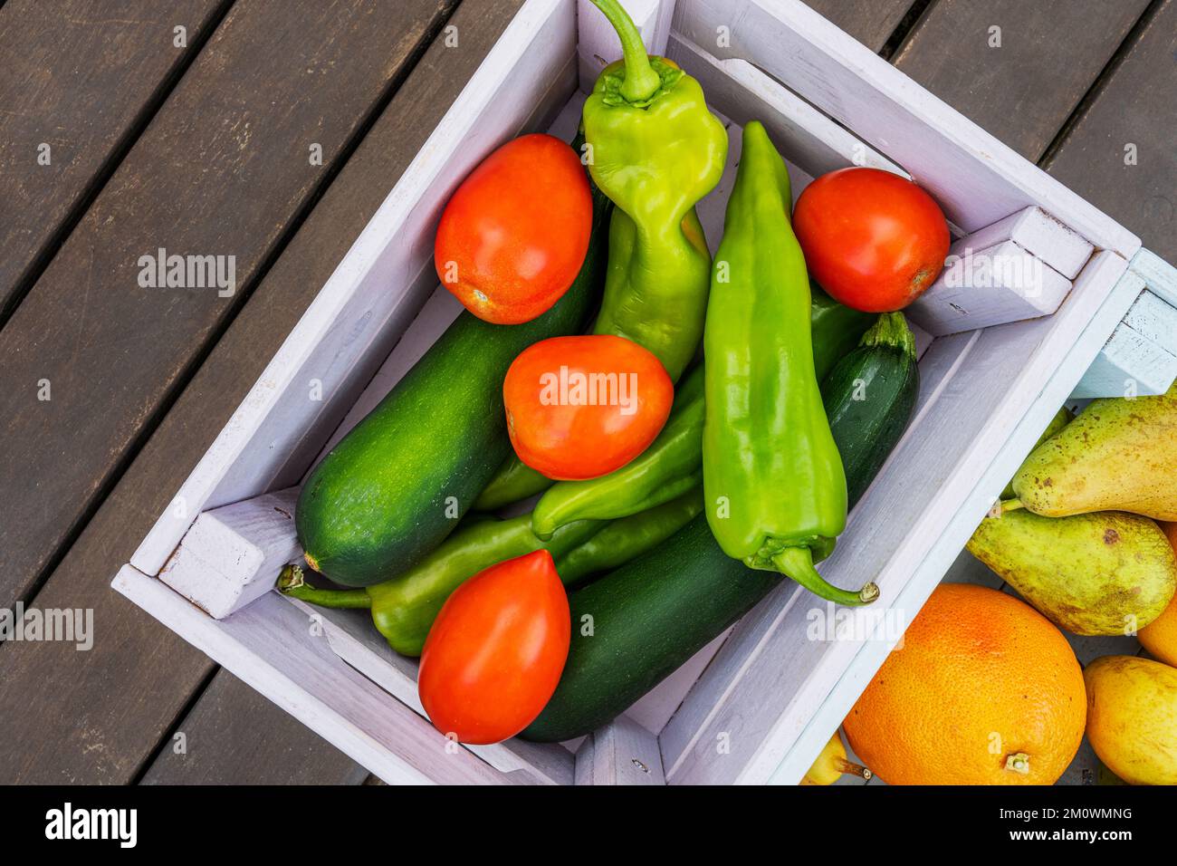 Some fresh fruits and tomatoes with Italian green peppers inside a ...