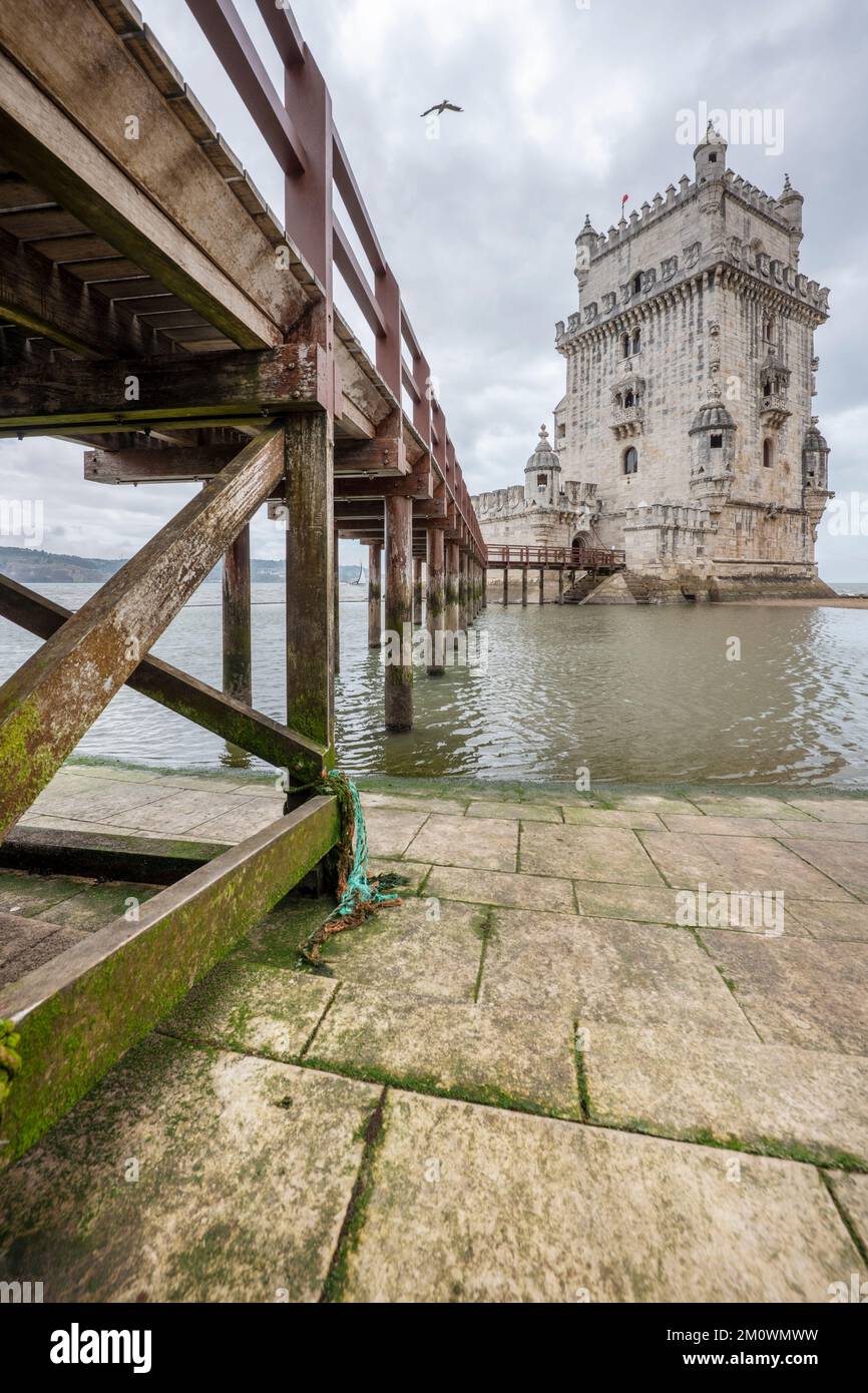 Views of the Belem tower in Portugal from the seaside next to a wooden ...
