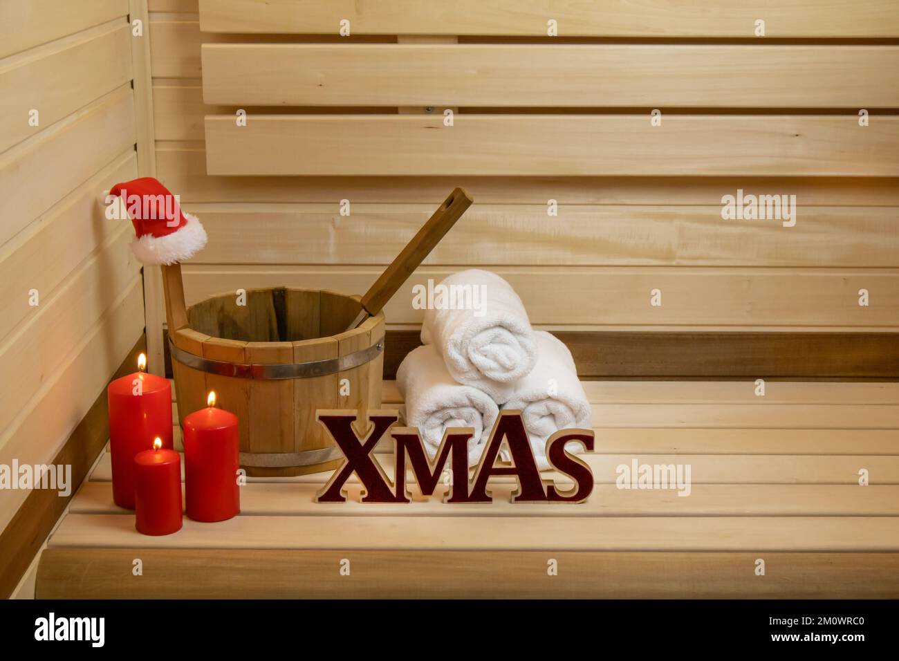 Sauna. Wooden bucket, burning candles, towels and santa's hat, Xmas ...