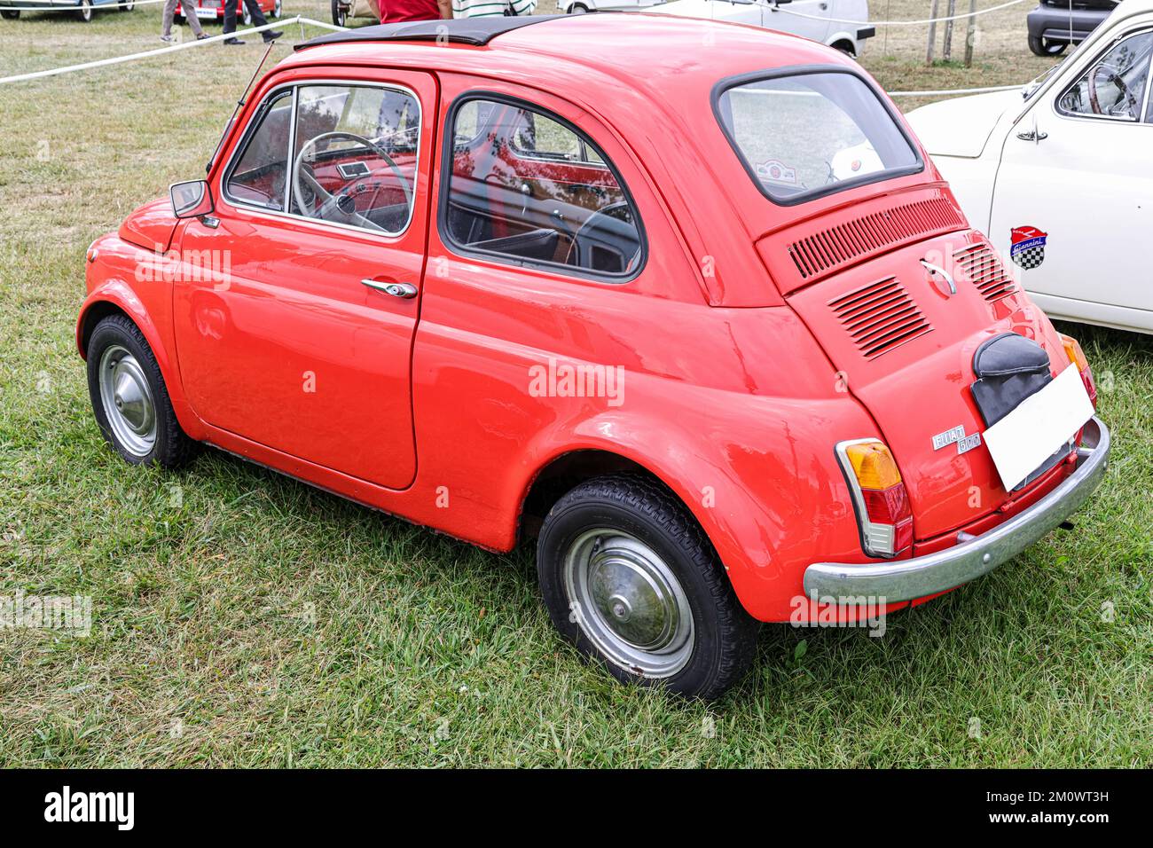 A rear view of a classic red Fiat model 600D small car in a field Stock ...
