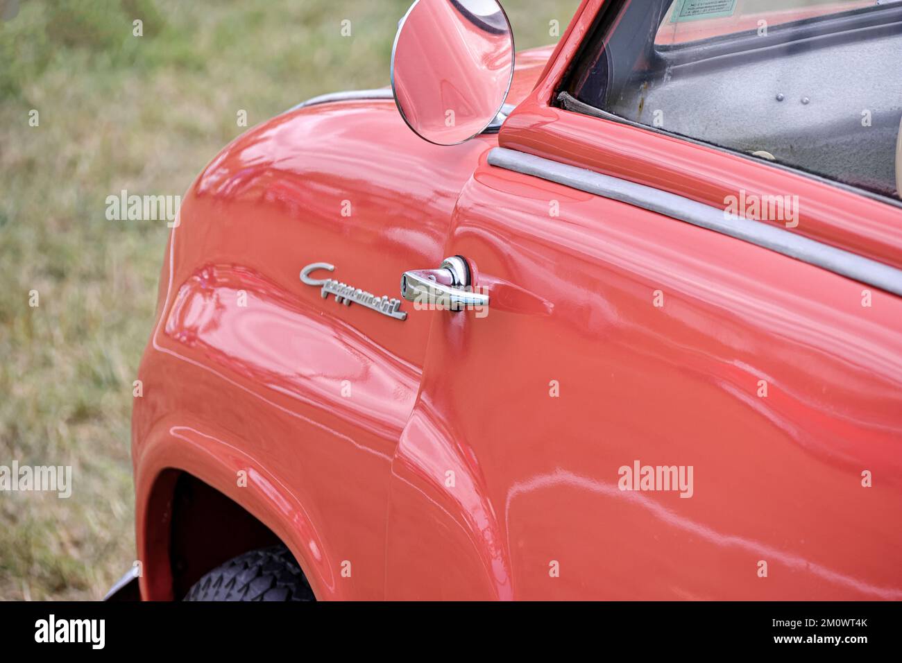 A closeup of the door with silver knob of a classic red Goggomobil T250 ...