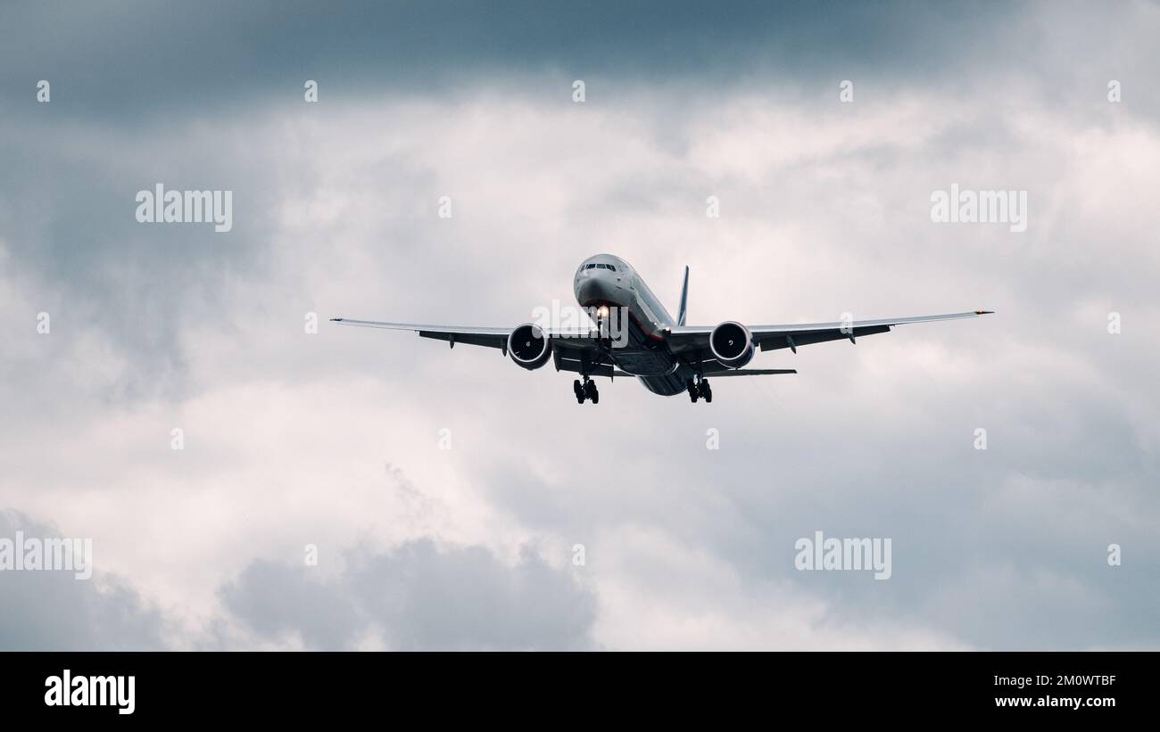 Passenger plane comes in for landing in cloudy weather Stock Photo - Alamy