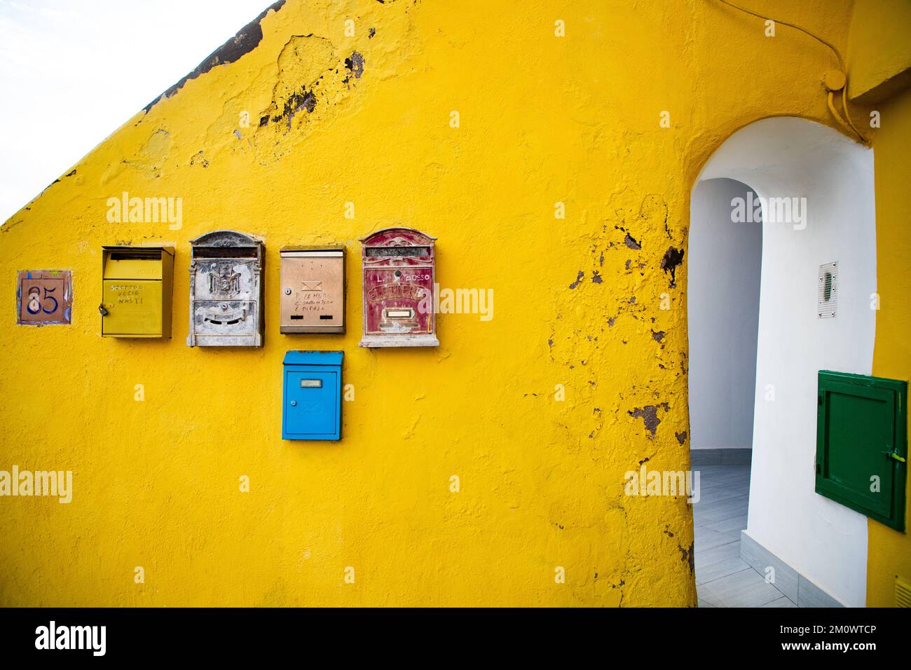 letter boxes on yellow wall Stock Photo - Alamy